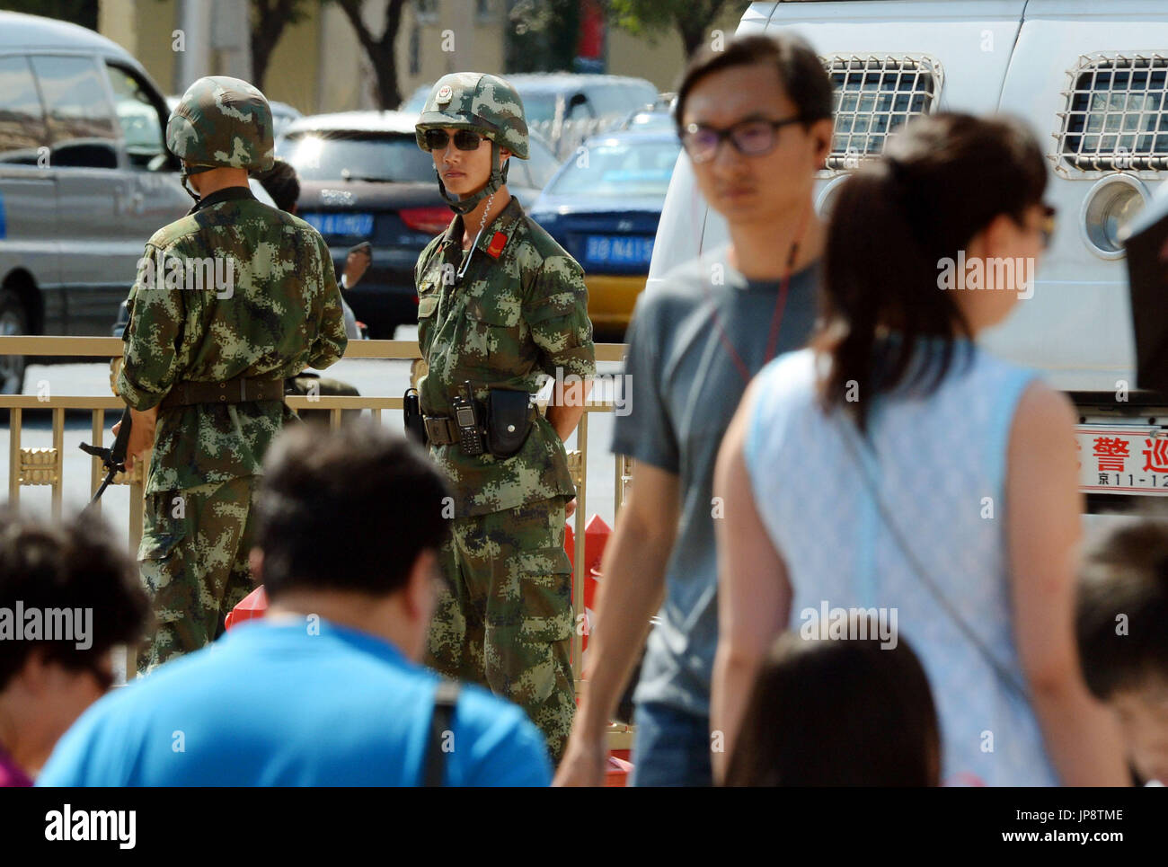Armed police officers stand on guard at a subway entrance in Beijing on ...