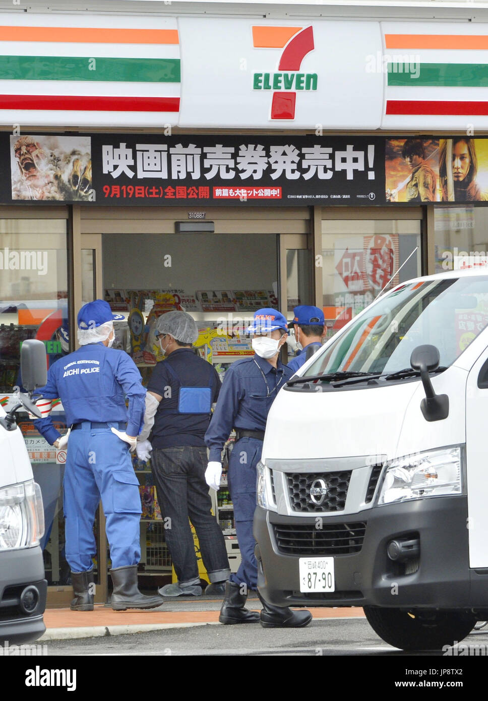 Police officers inspect a convenience store in the central Japan city ...