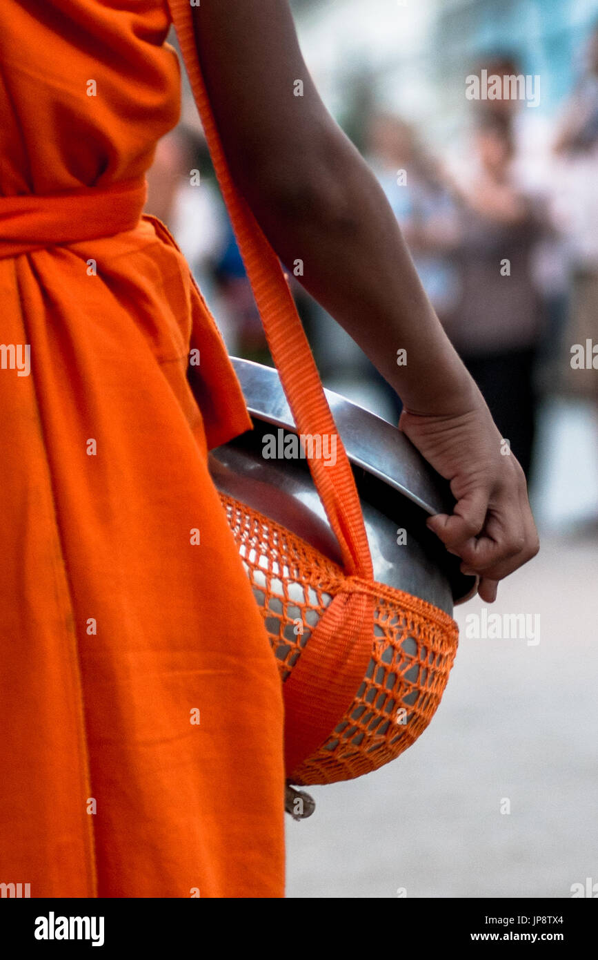 Hand of young monk carrying a basket to collect food and money for the ...