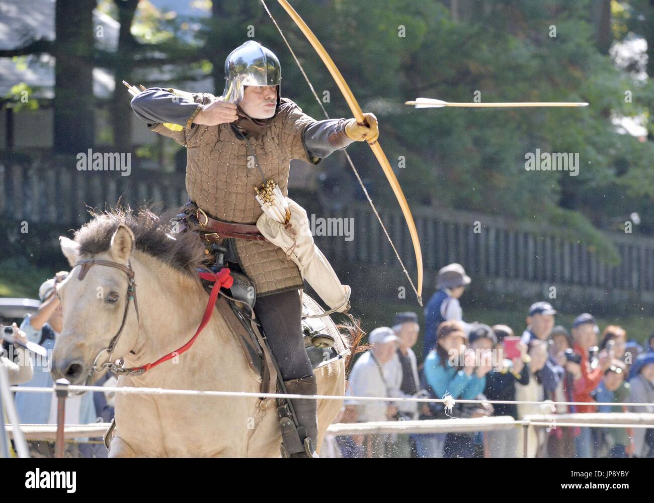 An archer on a running horse shoots an arrow at a target during an ...