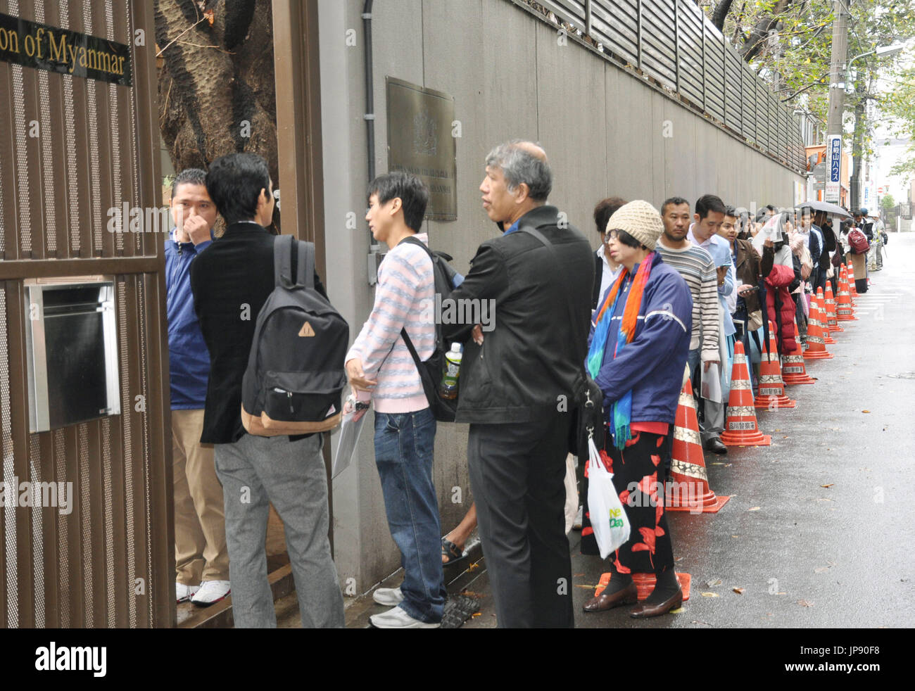 Myanmar nationals wait in line outside the Myanmar Embassy in Tokyo on ...