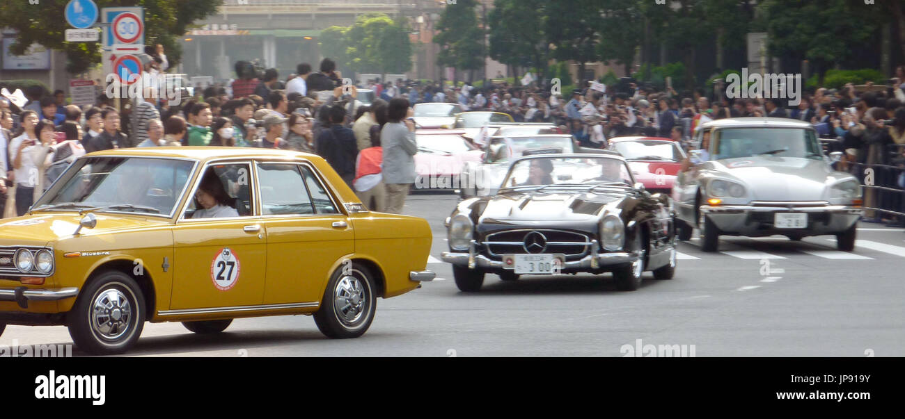 Around 80 famed cars, some from years past, take part in a motorcade ...