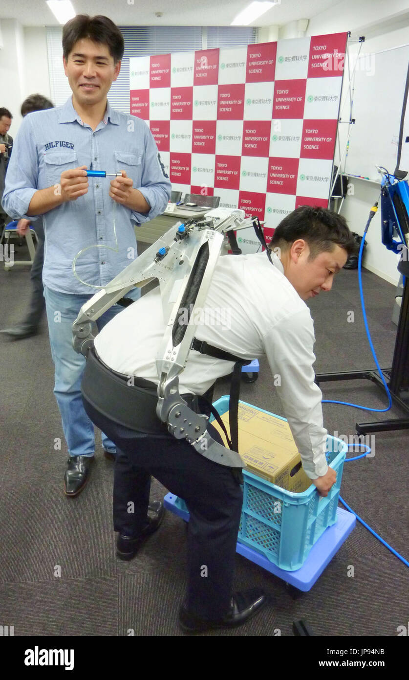 A person (R) wearing a new type of Muscle Suit developed by Innophys Co ...