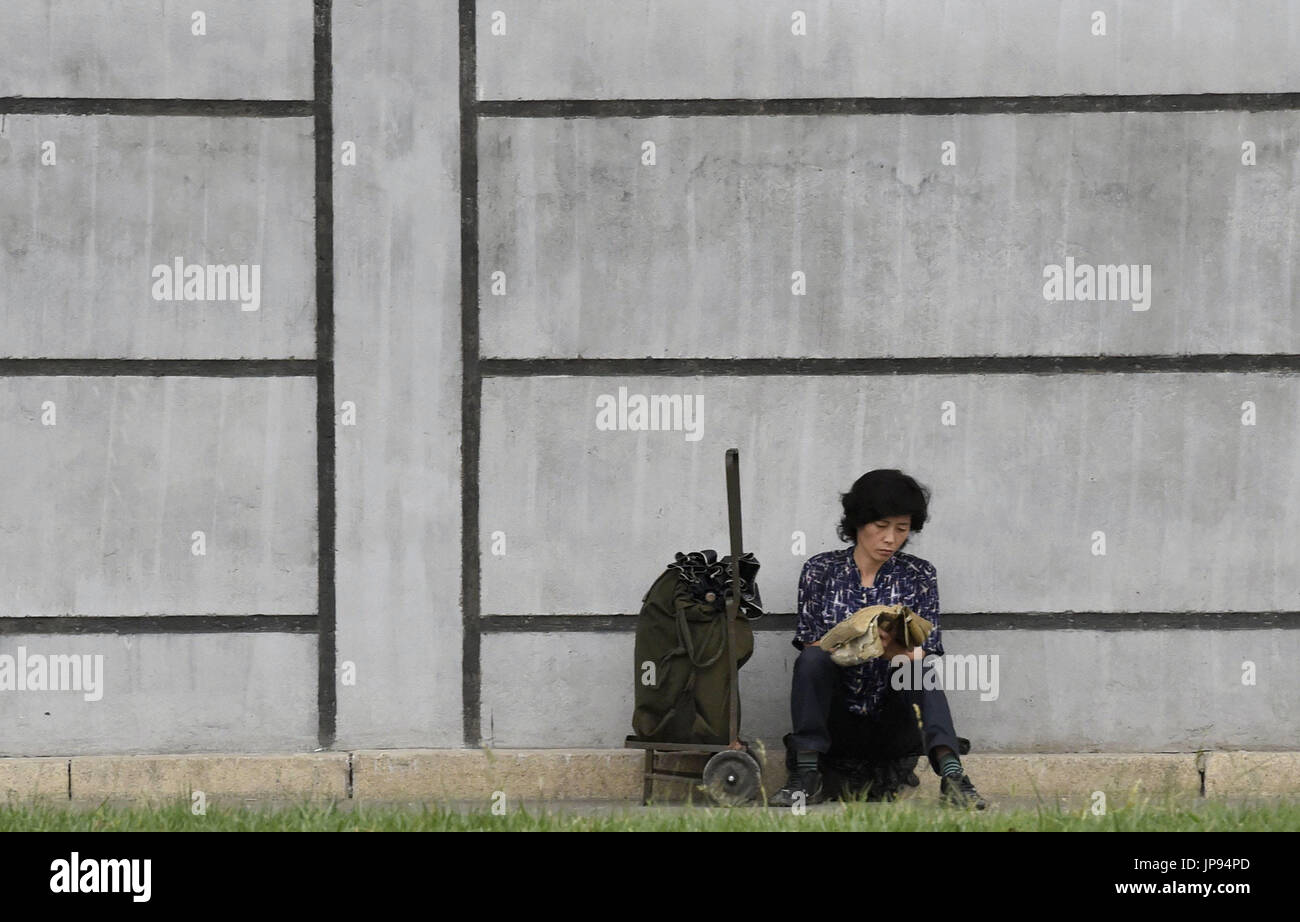 A woman reads what looks like a beat-up book in Pyongyang on Sept. 11 ...