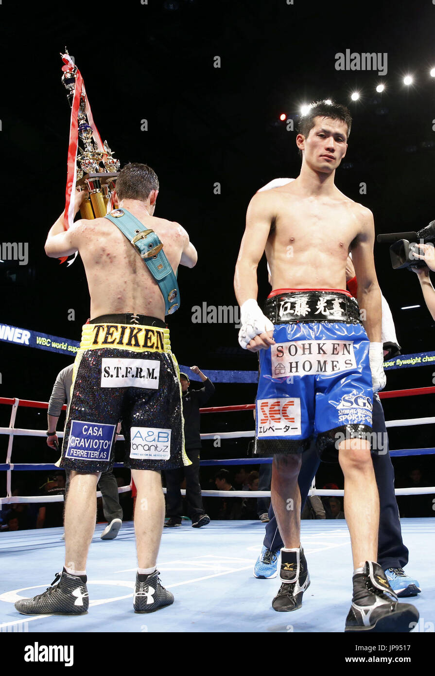Champion Carlos Cuadras of Mexico (L) hefts the trophy after defending ...
