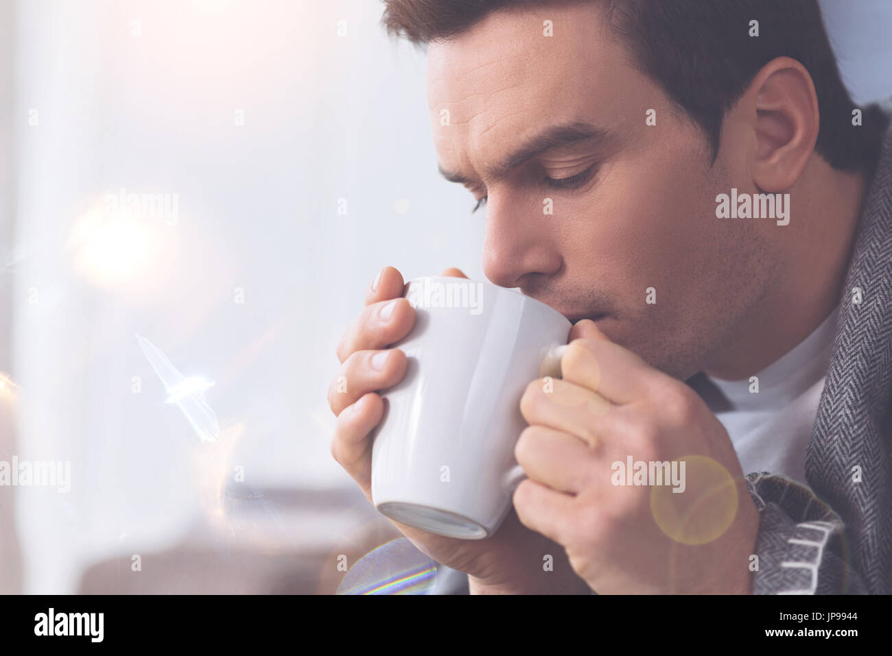 Portrait of sick male person keeping cup near lips Stock Photo - Alamy