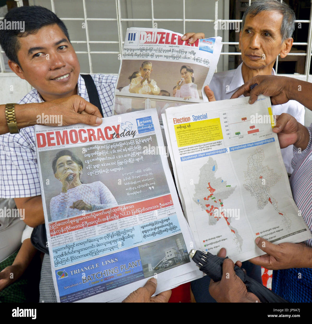 People hold up newspapers reporting on favorable election results for ...