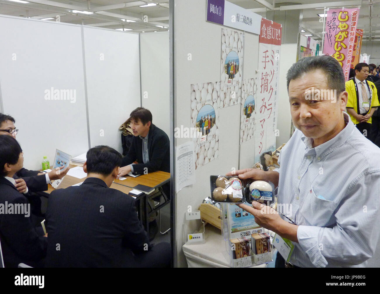 A Mitsukura Norin Y.K. official (far R) makes a pitch for its mushrooms ...