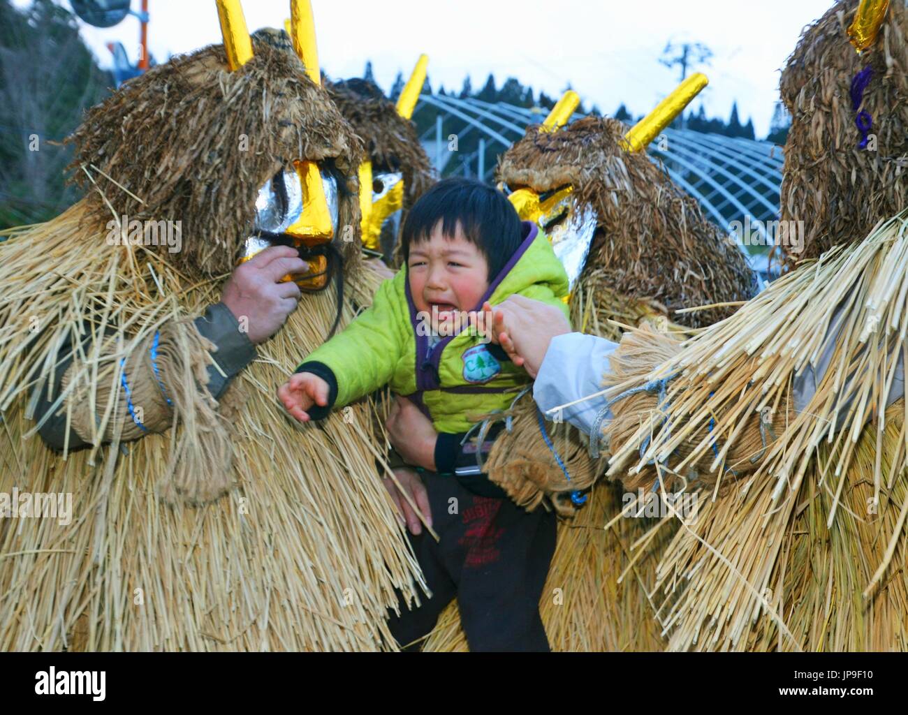 A child cries while being lifted by a man disguised as "Namahage ...