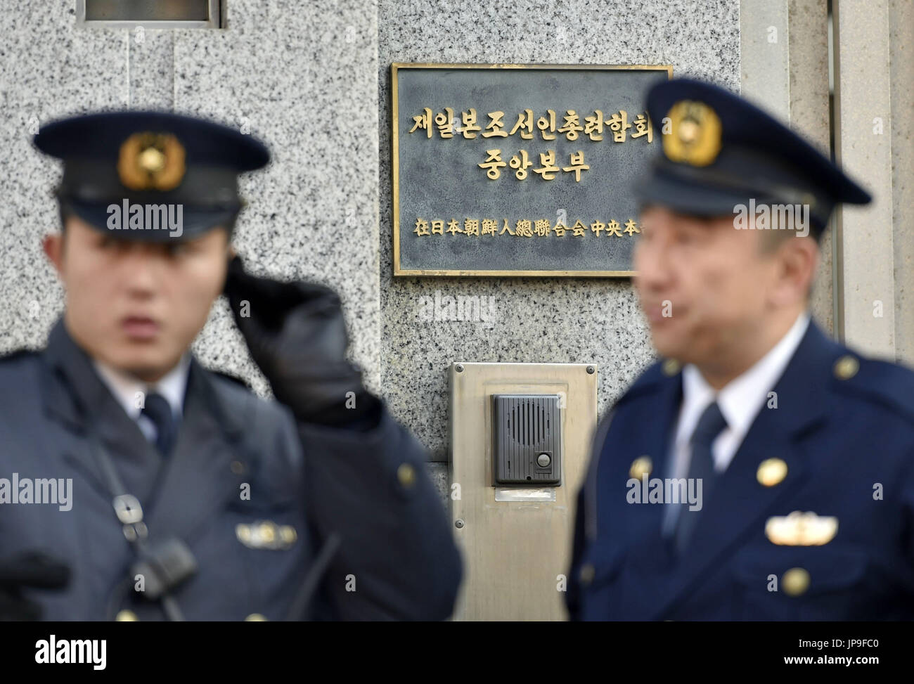 Police officers stand guard in front of the headquarters in Tokyo of ...