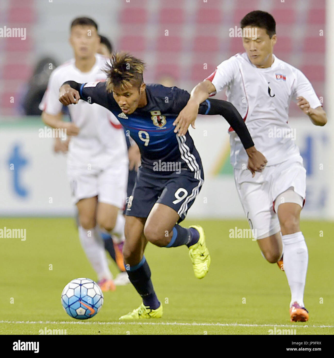 Musashi Suzuki (9) of Japan's Under-23 team holds off a North Korean ...