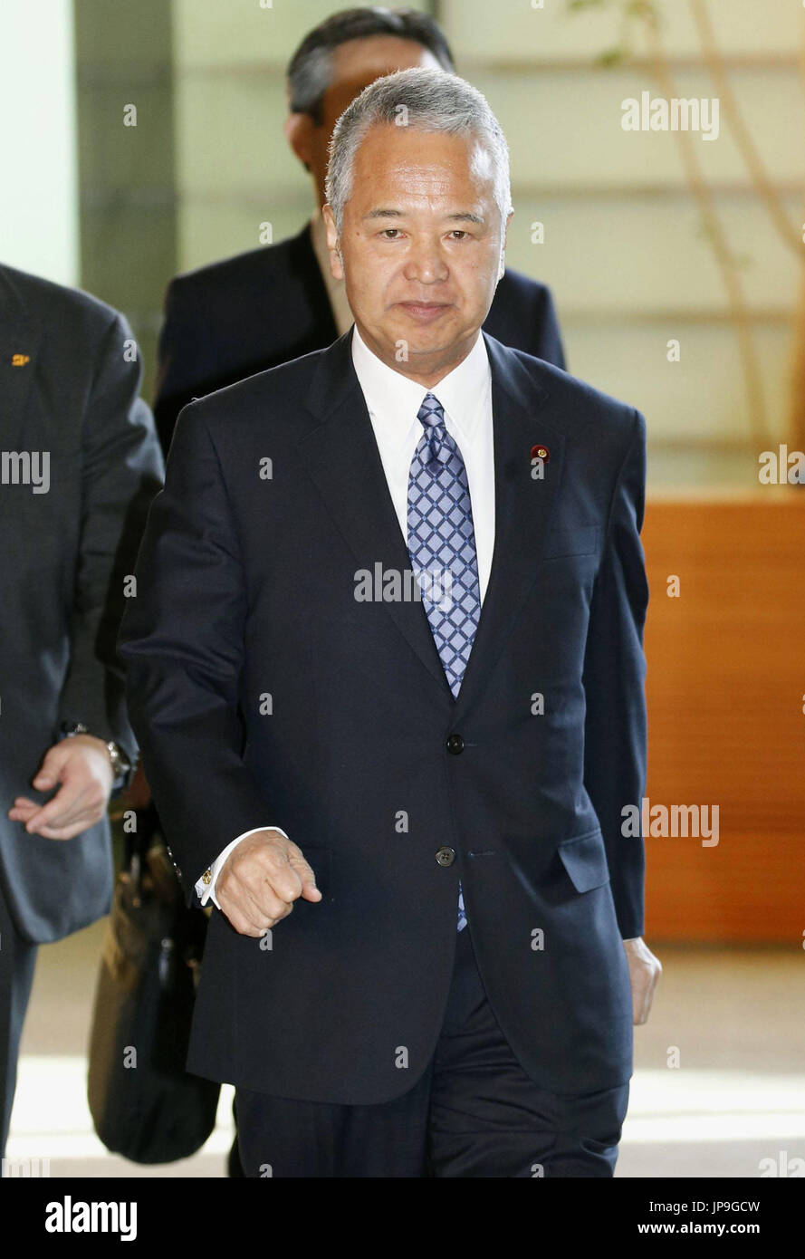 Japanese Economic and Fiscal Policy Minister Akira Amari heads to a ...