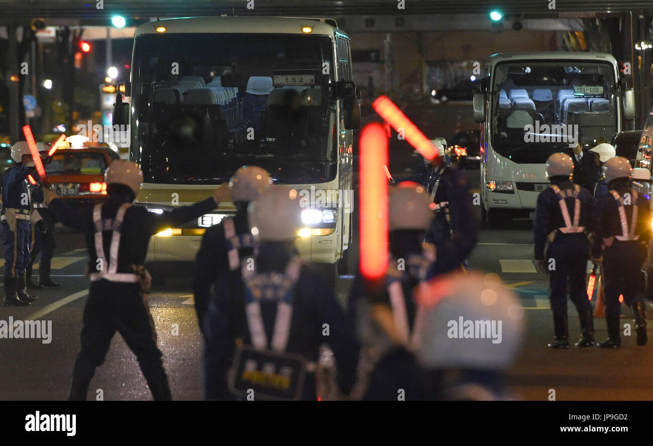 Police officers direct buses to a surprise inspection in Tokyo on Jan ...