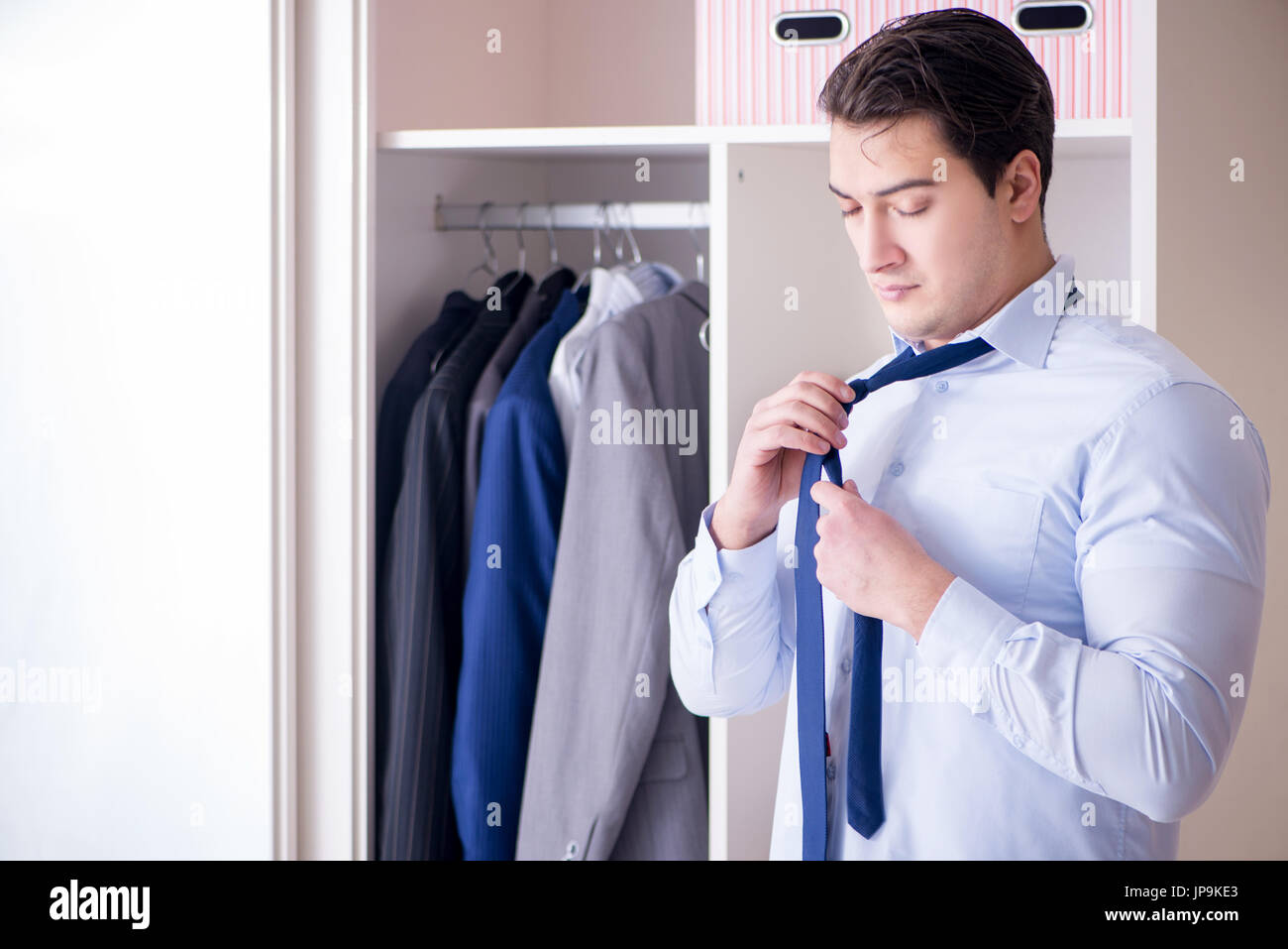 Young man businessman getting dressed for work Stock Photo - Alamy
