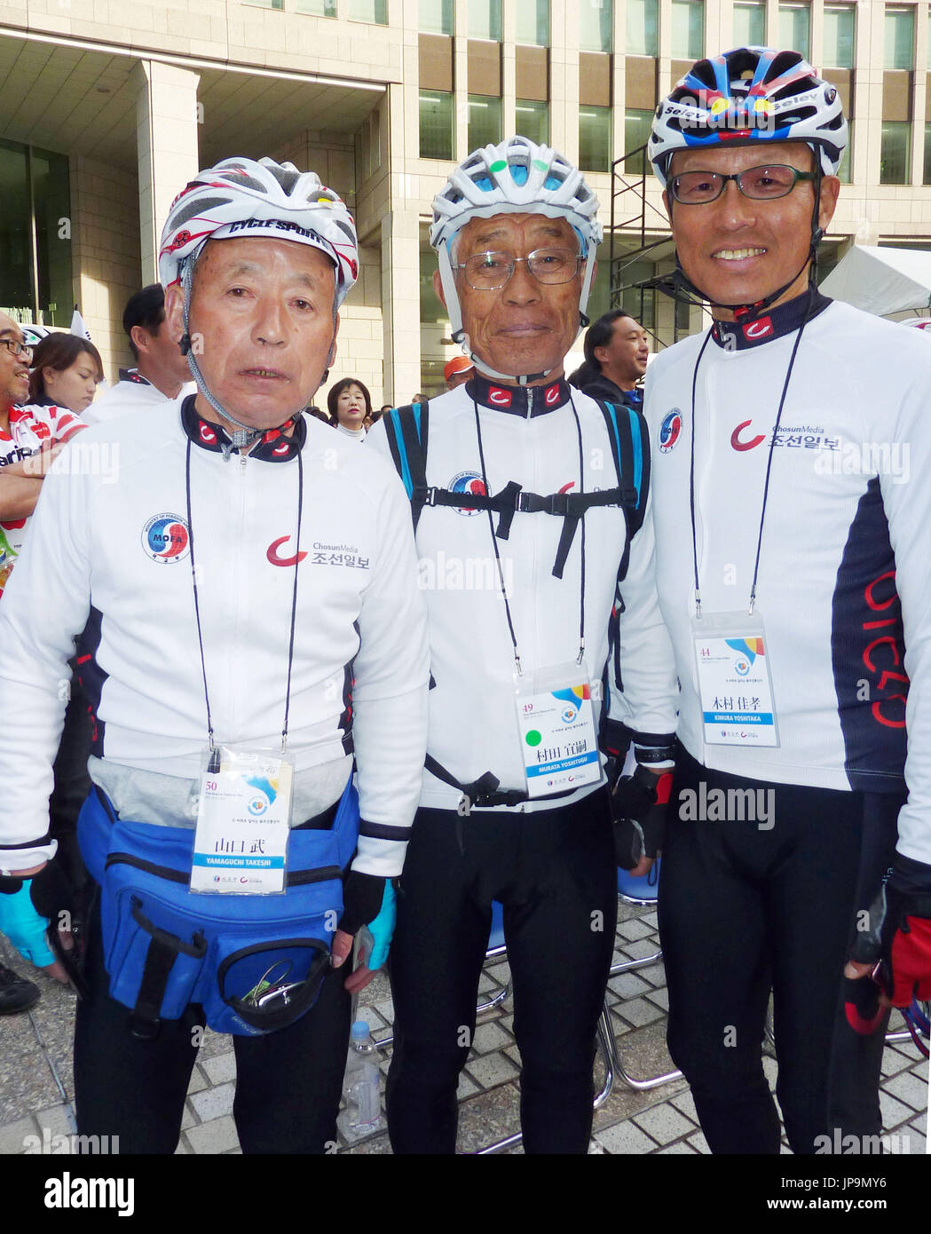 Three cyclists, including 79-year-old Takeshi Yamaguchi (L) of Japan ...