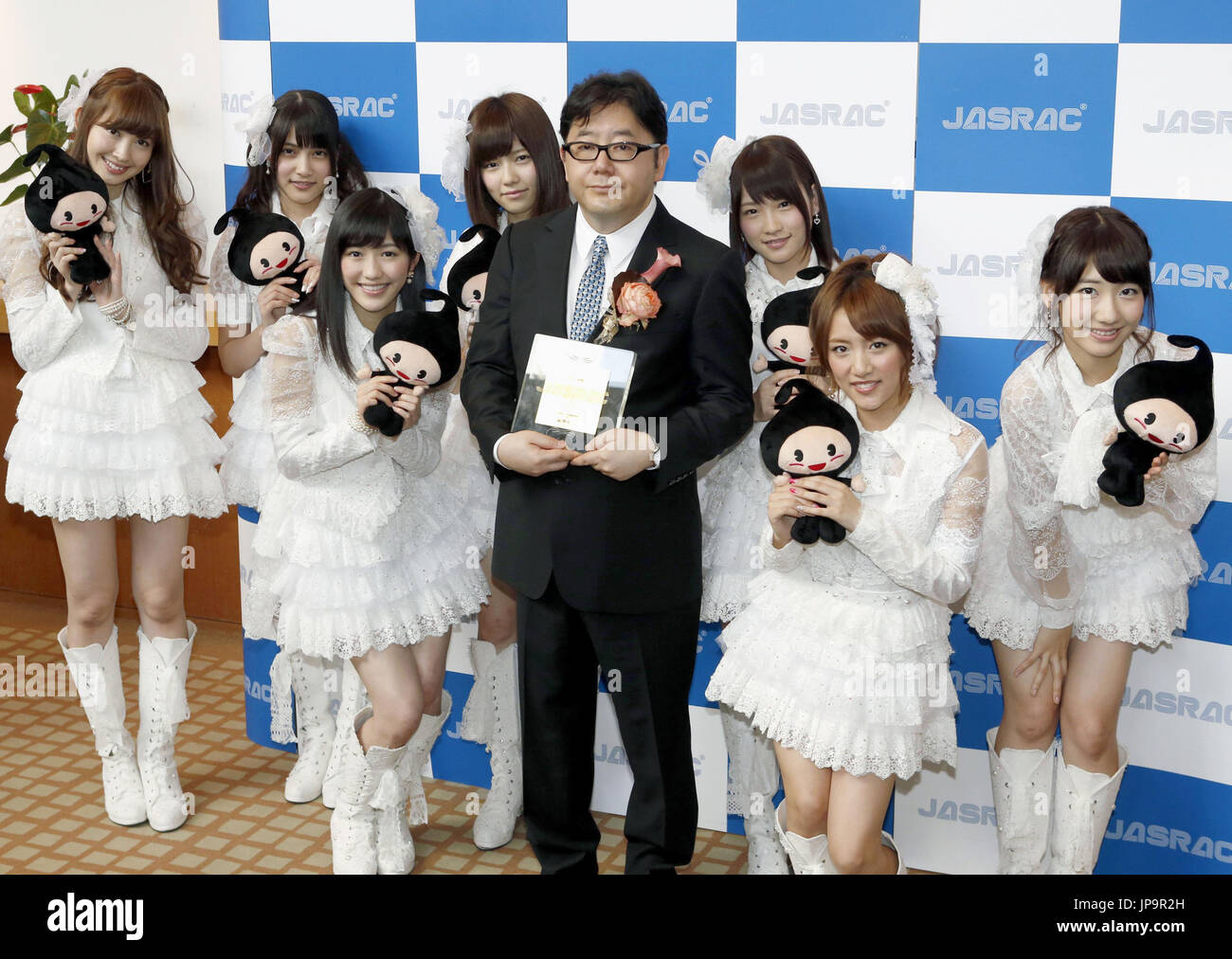 Songwriter Yasushi Akimoto (C) is surrounded by members of the Japanese ...
