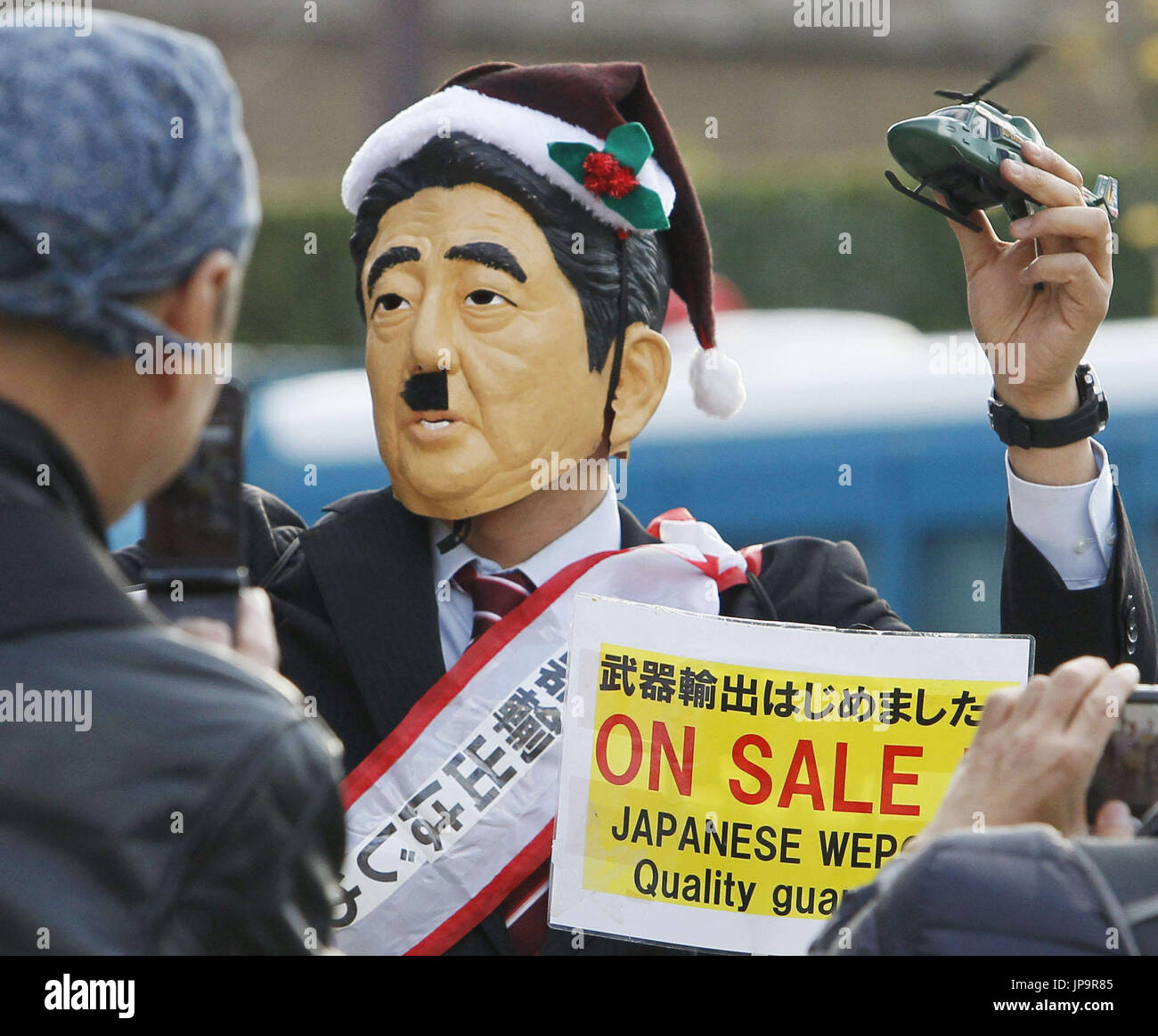 A protester wearing a mask of Prime Minister Shinzo Abe demonstrates in ...