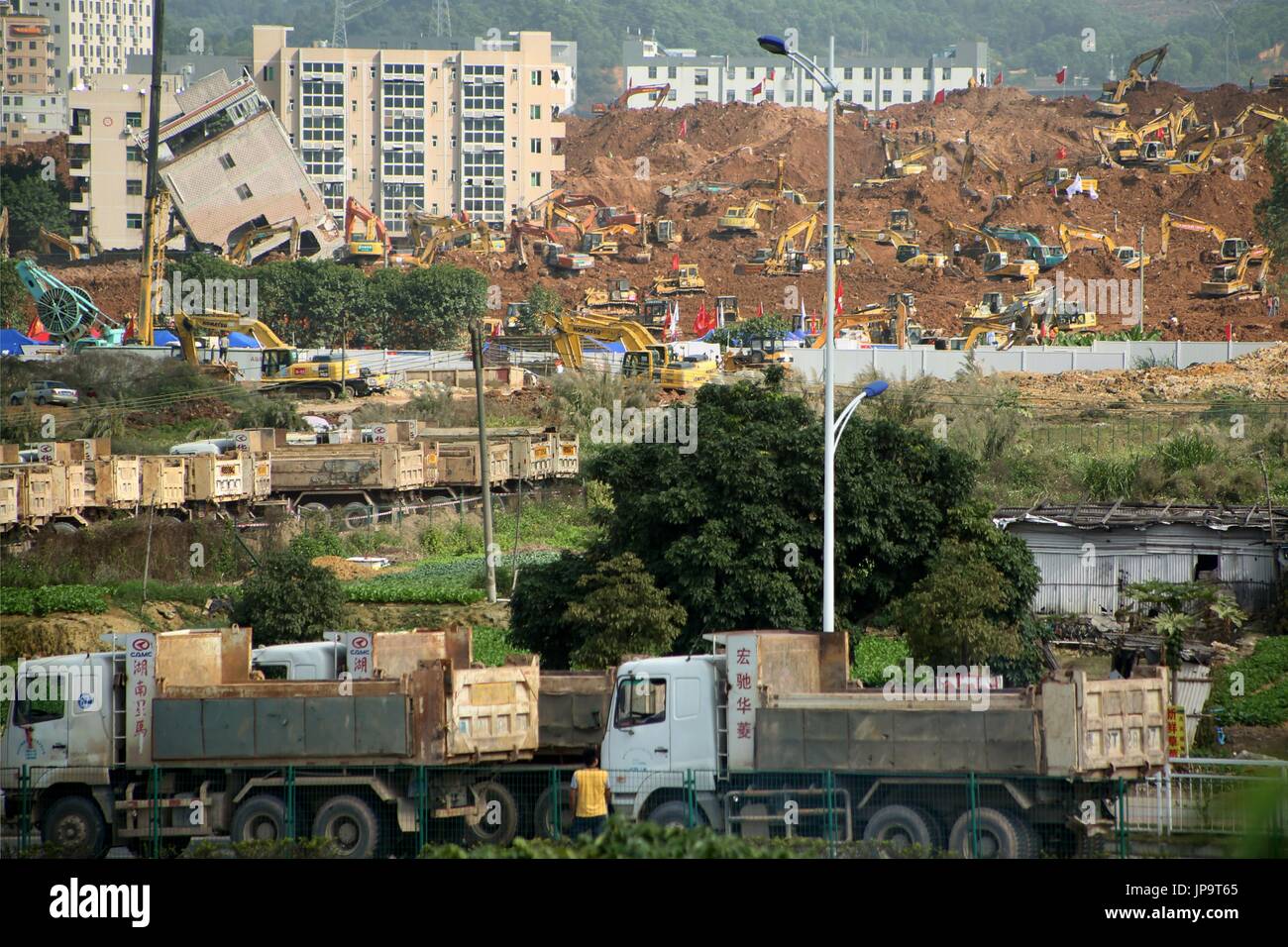 Heavy trucks stand by on Dec. 24, 2015, to carry sand and debris ...