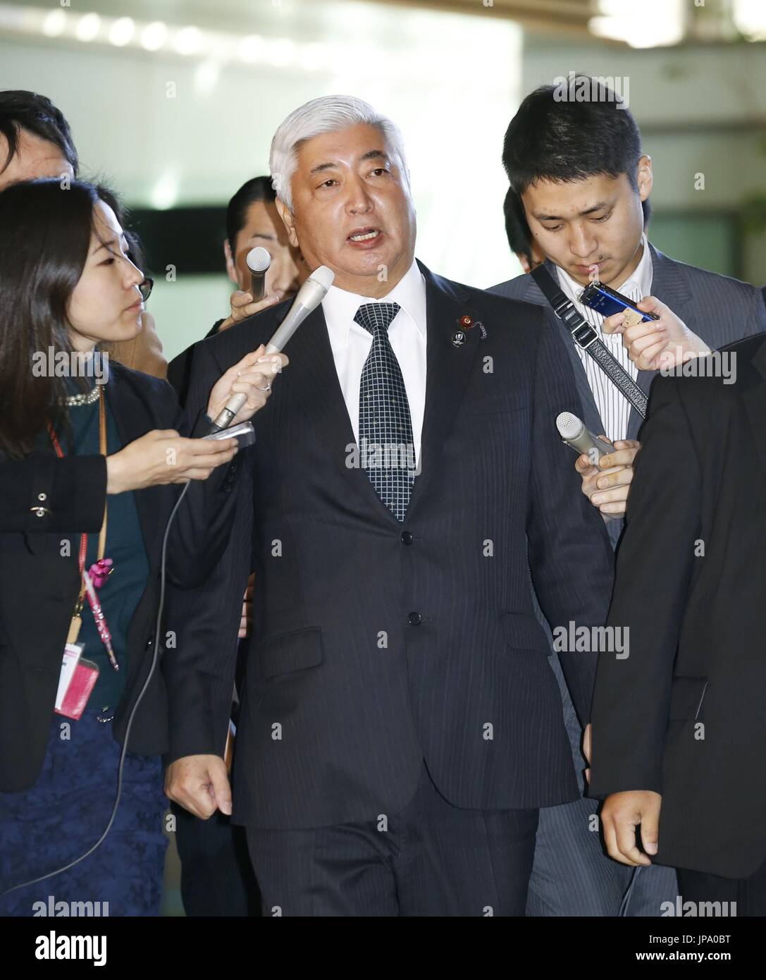 Japanese Defense Minister Gen Nakatani, surrounded by reporters ...