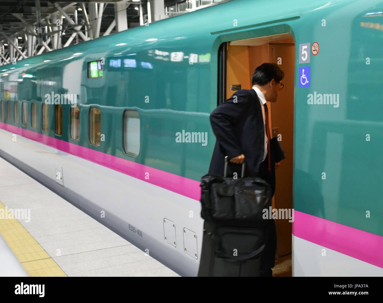 A businessman gets on a Hokkaido Shinkansen bullet train at JR Shin ...