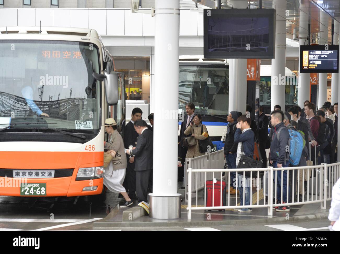 Passengers board a bus at the Shinjuku Express Bus Terminal in central ...