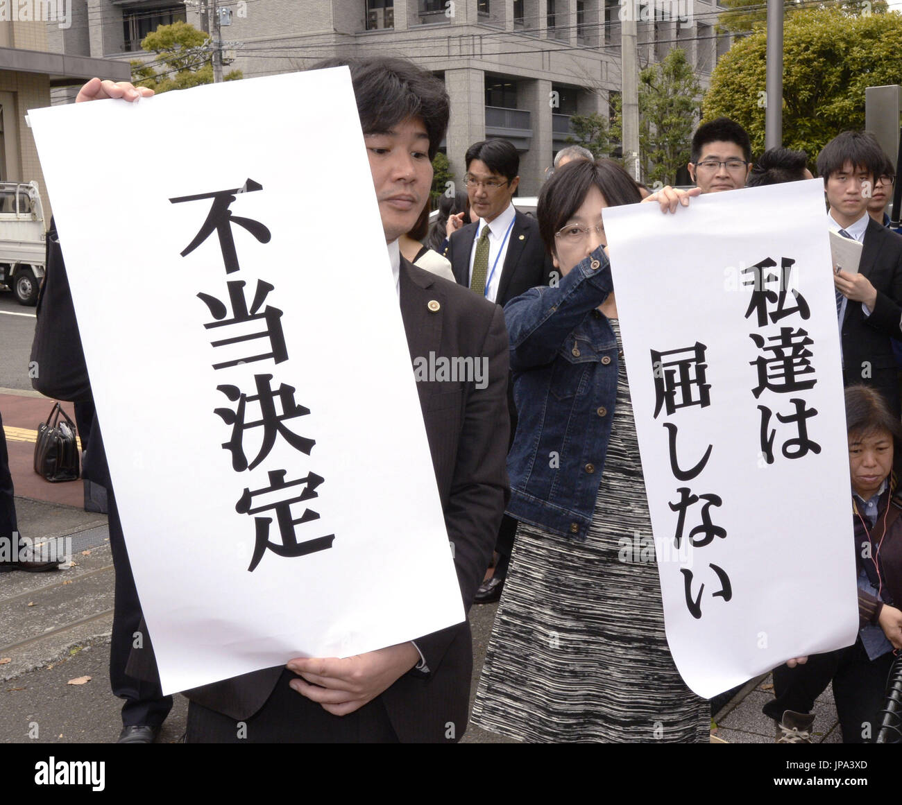 Lawyers hold banners, reading "An unjust decision" and "We will not ...
