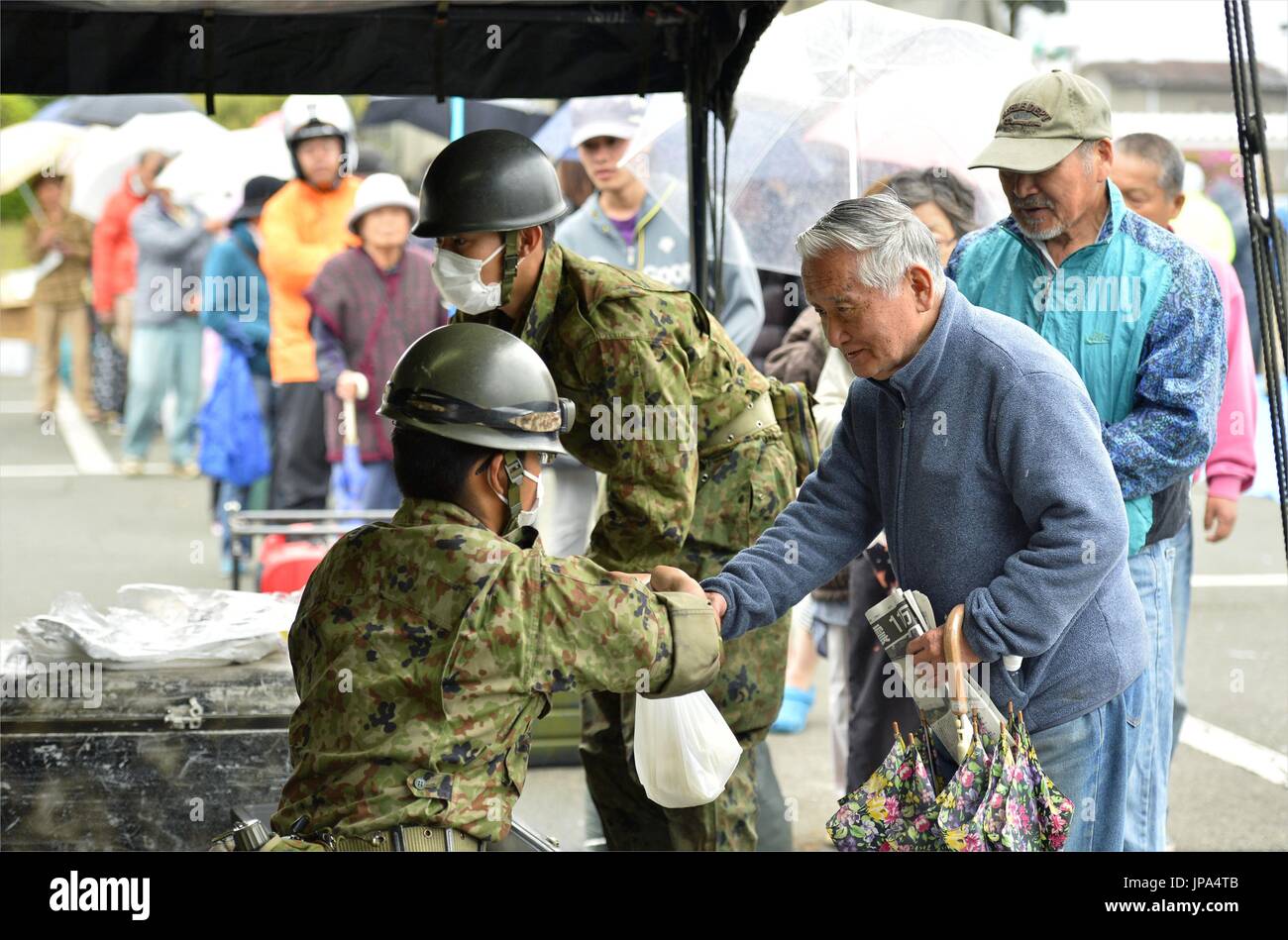Evacuees from a series of earthquakes receive food in the southwestern ...
