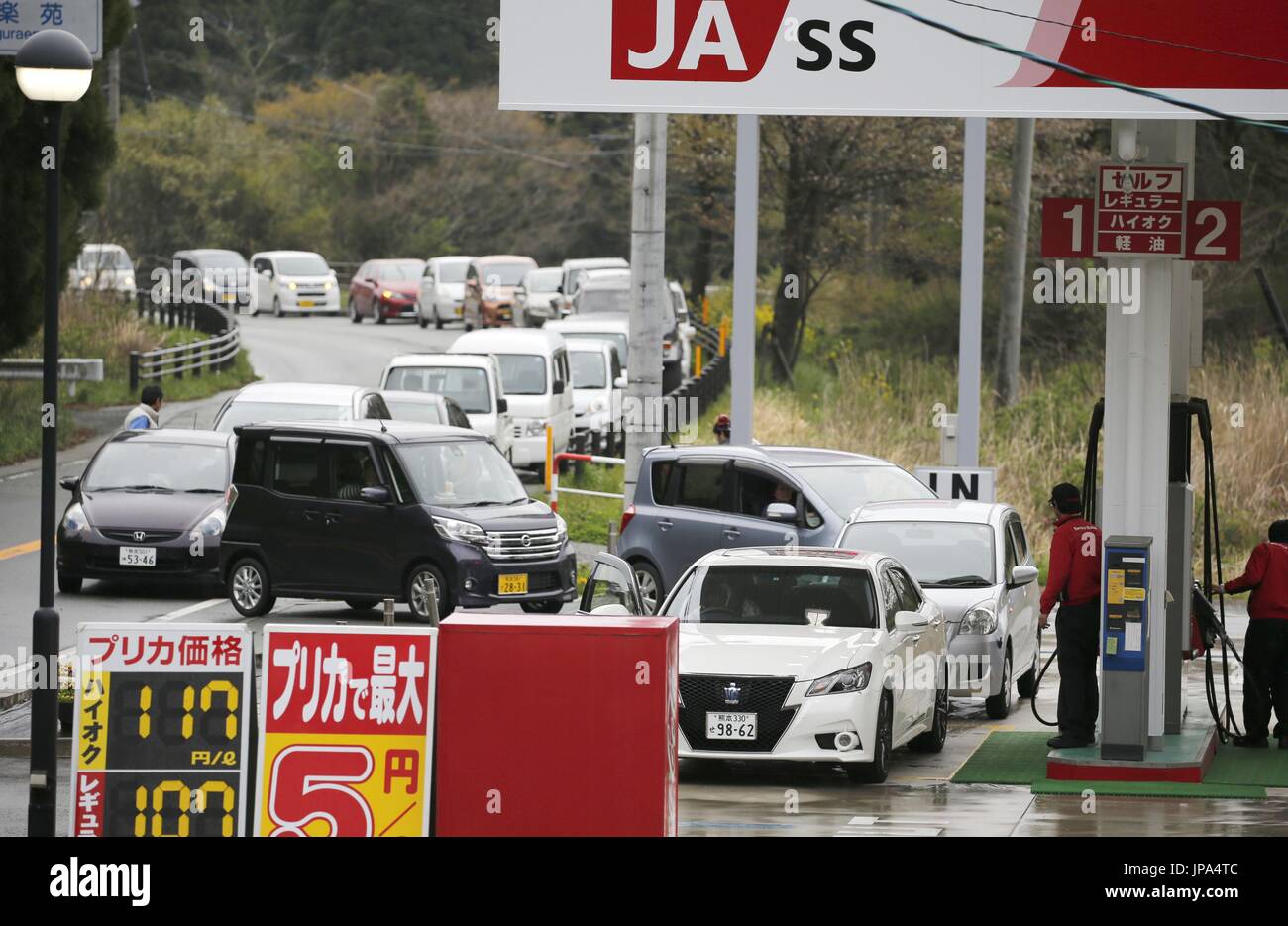 Cars line up in front of a gas station in the southwestern Japan city ...
