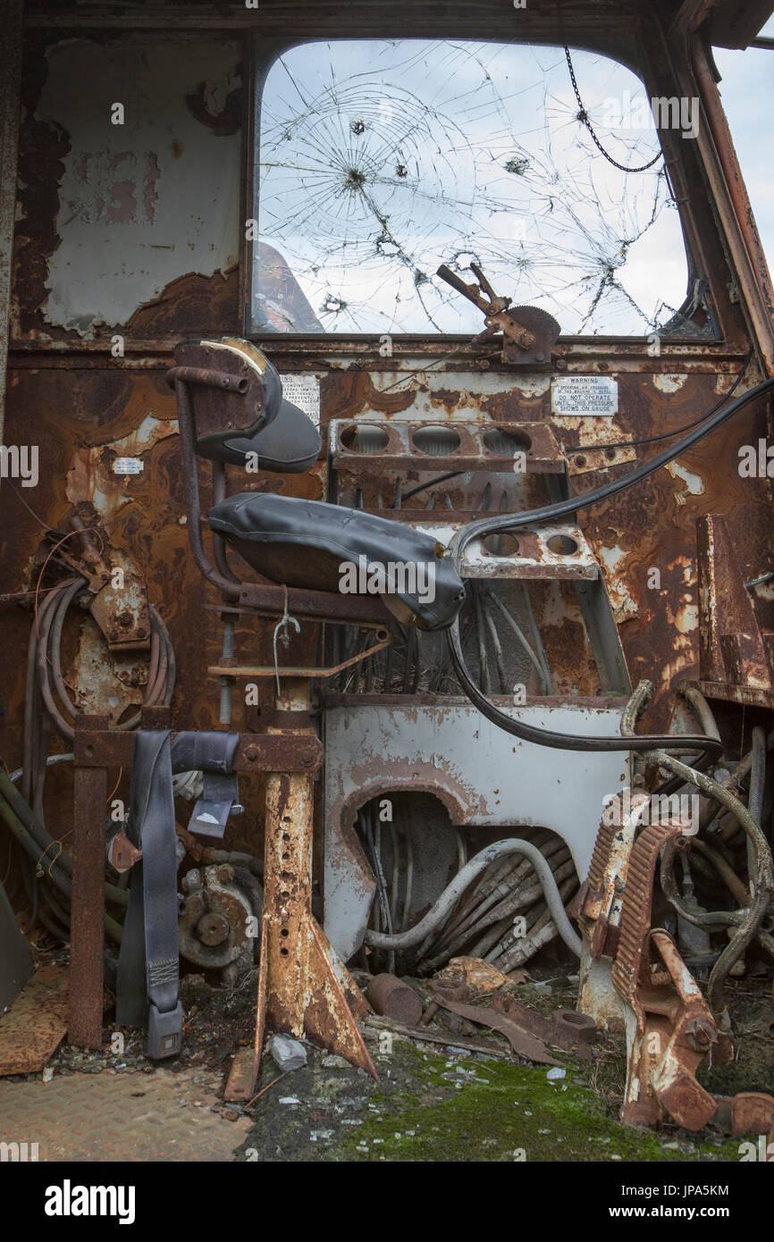 Rusty interior and seat in heavy machinery cab with broken window Stock ...