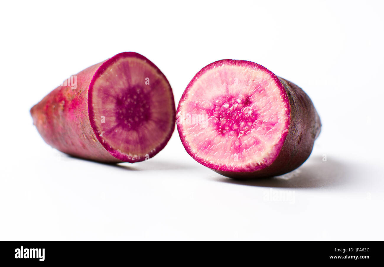 Raw purple potato isolated on white background Stock Photo - Alamy