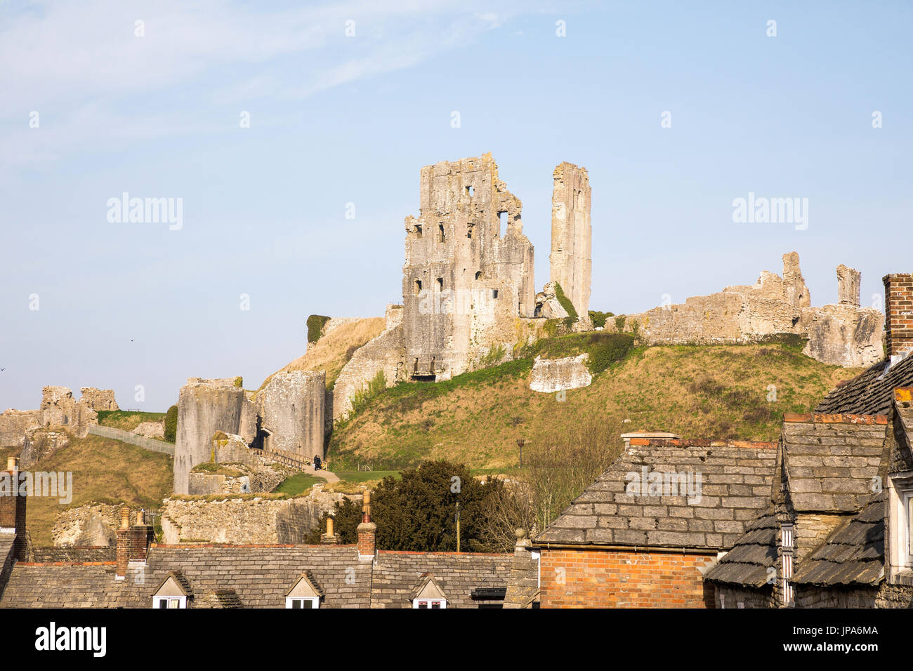 A distant view of the ruined castle from the town of Corfe Castle Stock ...