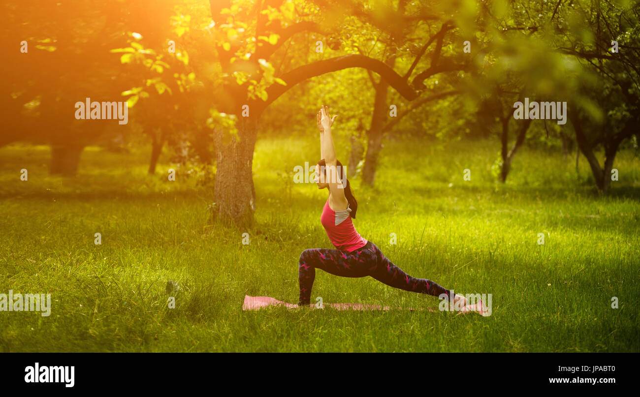 Woman practicing high lunge yoga pose Stock Photo - Alamy