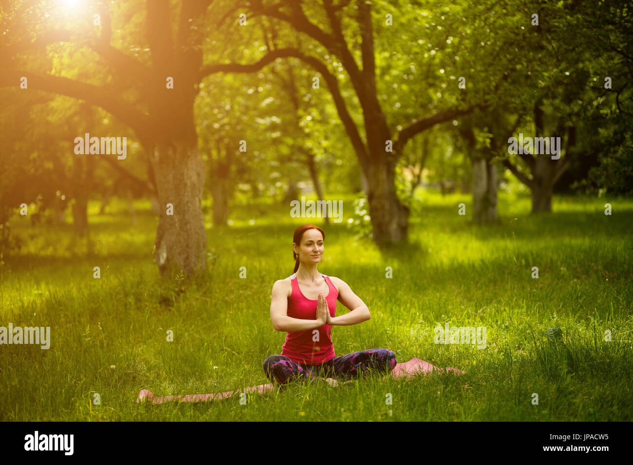 Woman sitting in yoga asana with crossed legs Stock Photo - Alamy