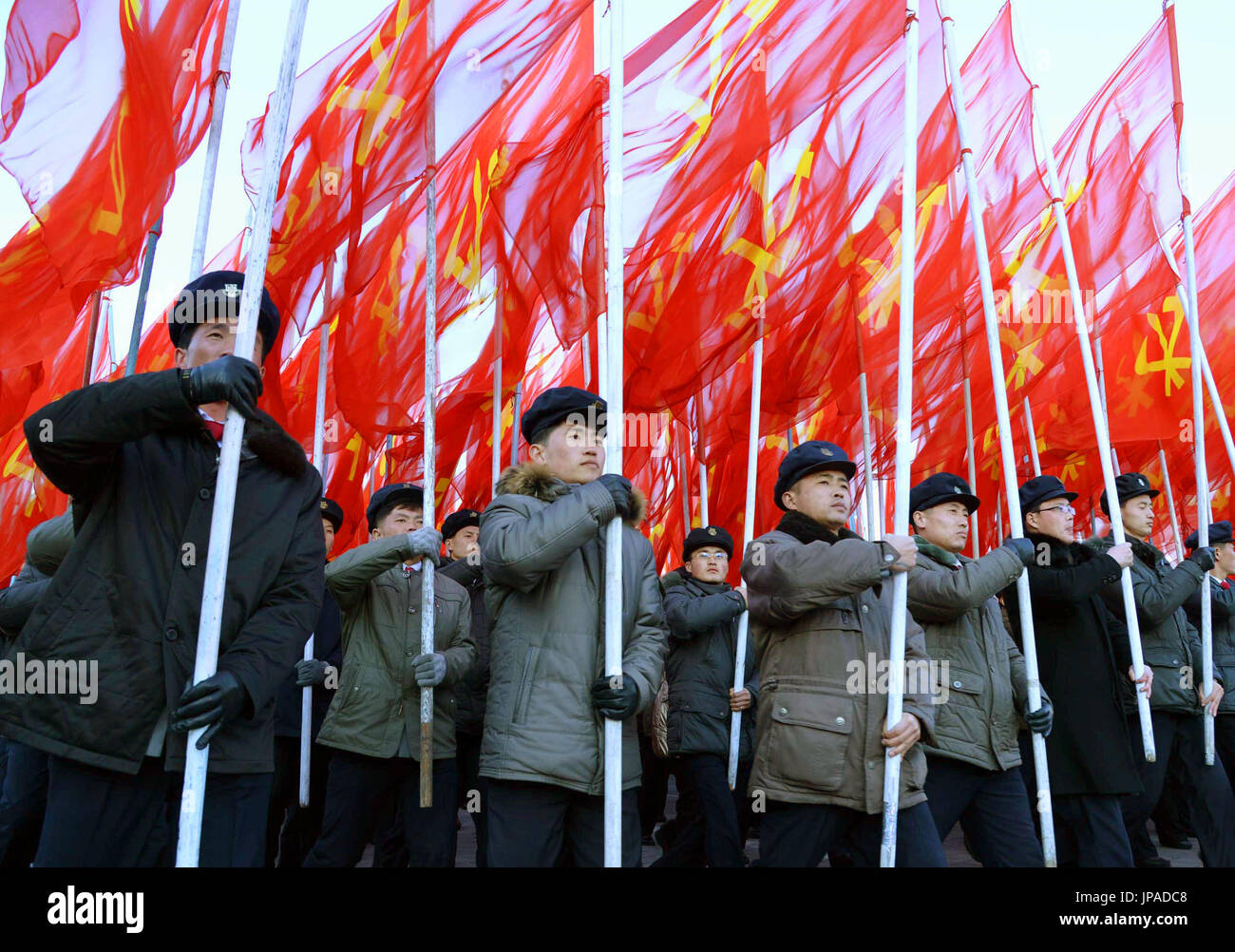 People march carrying flags of North Korea's Workers' Party during a ...