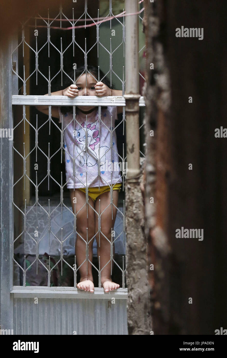 A girl looks out from her house in Rio de Janeiro's Rocinha, one of the ...
