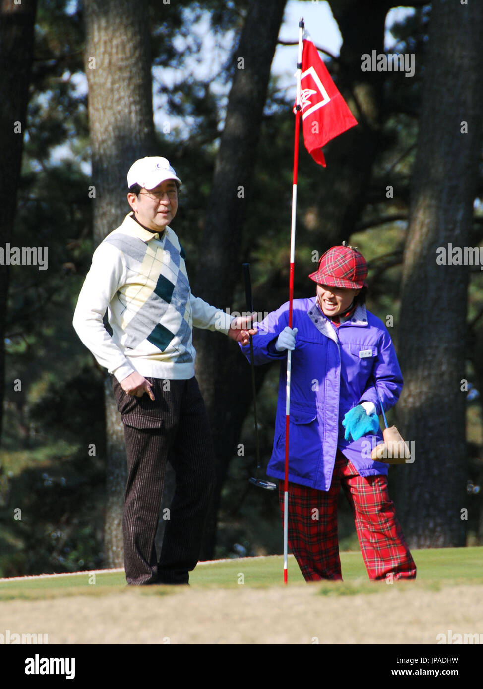 Prime Minister Shinzo Abe (L) enjoys a round of golf on Feb. 27, 2016 ...