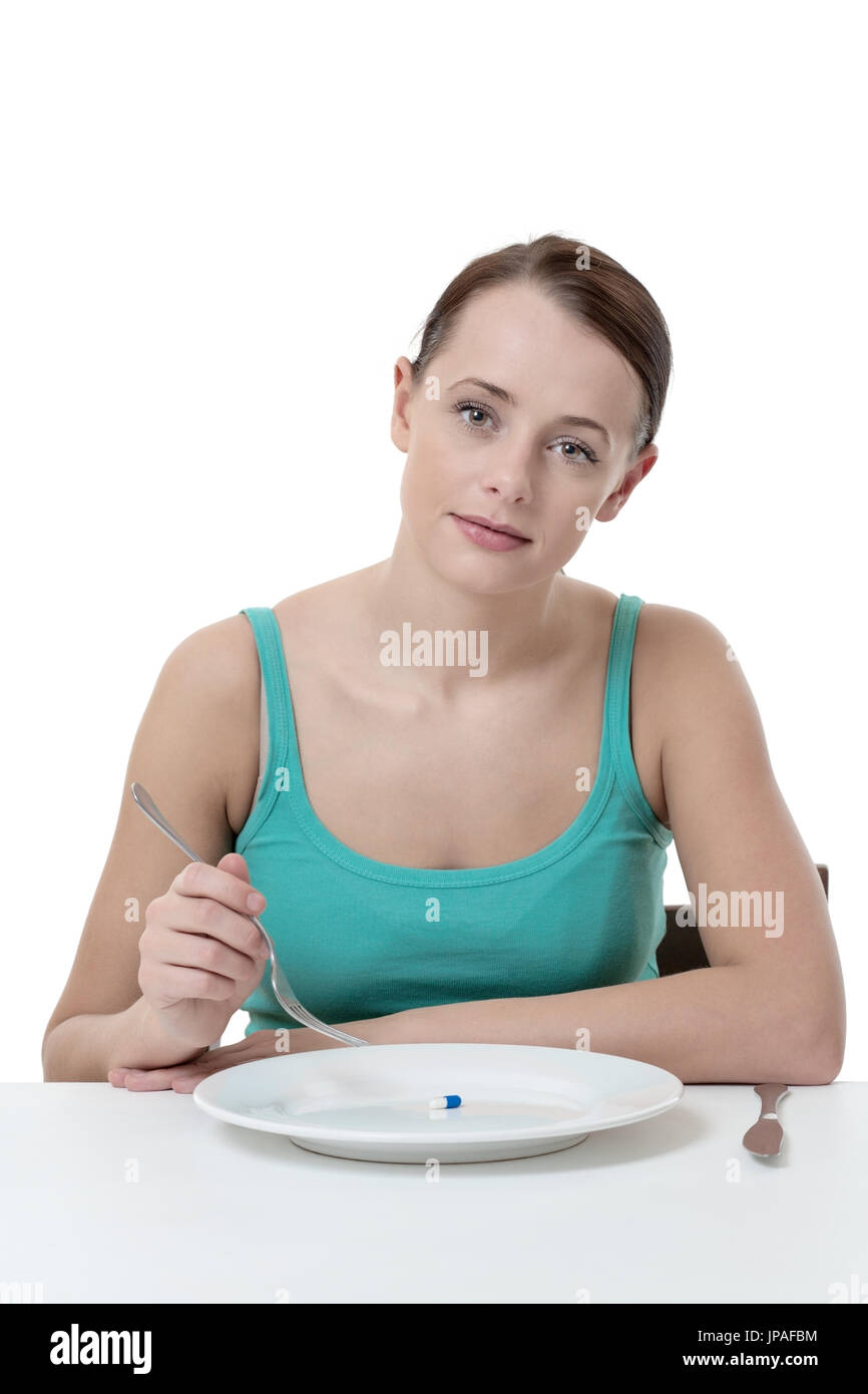 woman sitting at a tablet about to eat a single tablet Stock Photo - Alamy
