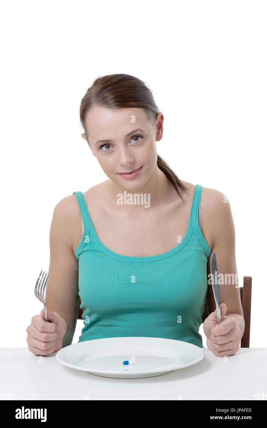 woman sitting at a tablet about to eat a single tablet Stock Photo - Alamy