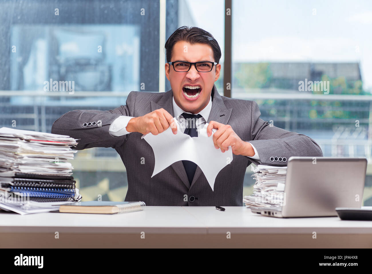 Angry businessman with too much work in office Stock Photo - Alamy