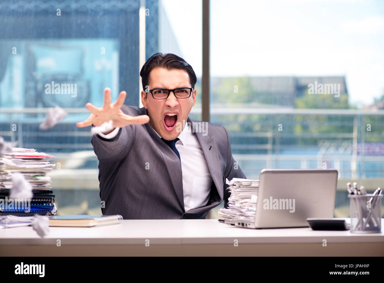 Angry businessman with too much work in office Stock Photo - Alamy