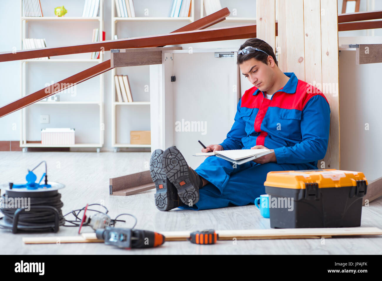 Young carpenter with notebook writing planning at construction repair ...