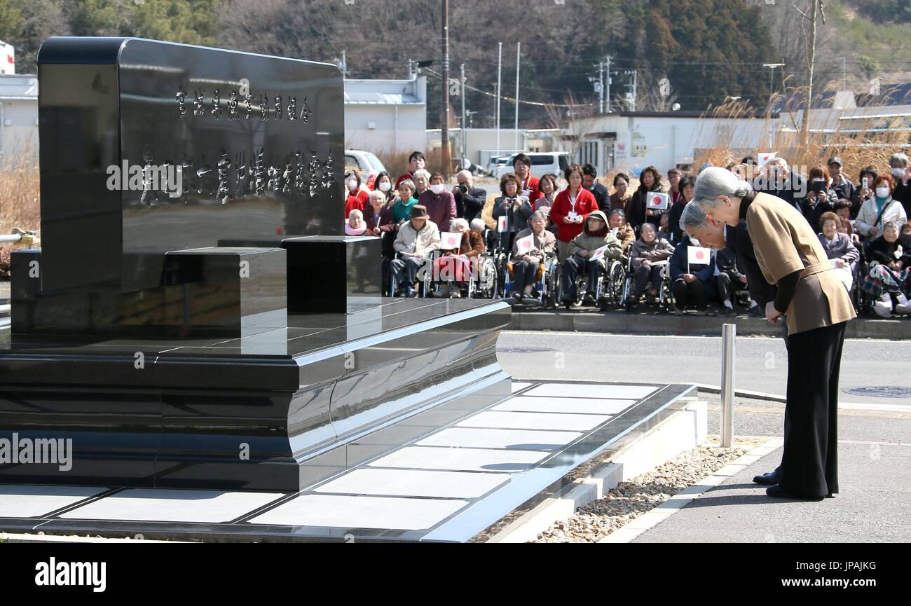 Emperor Akihito and Empress Michiko offer prayers in front of a ...