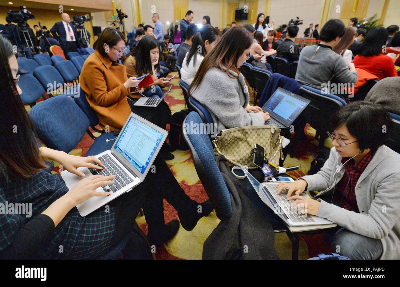 Female reporters write articles during a press conference at the ...