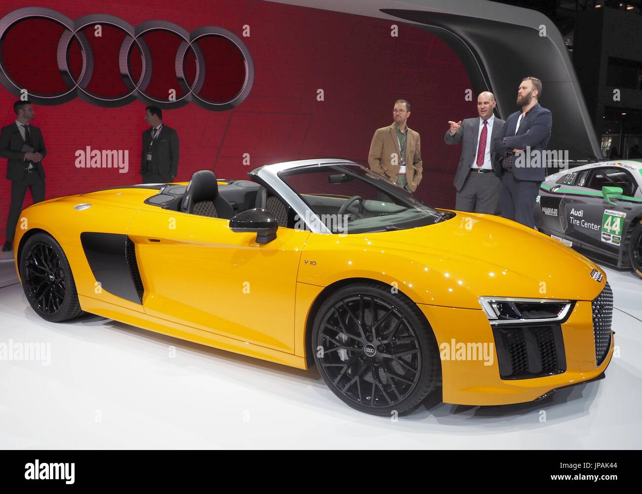 A bright yellow convertible version of the Audi R8 Spyder is displayed ...
