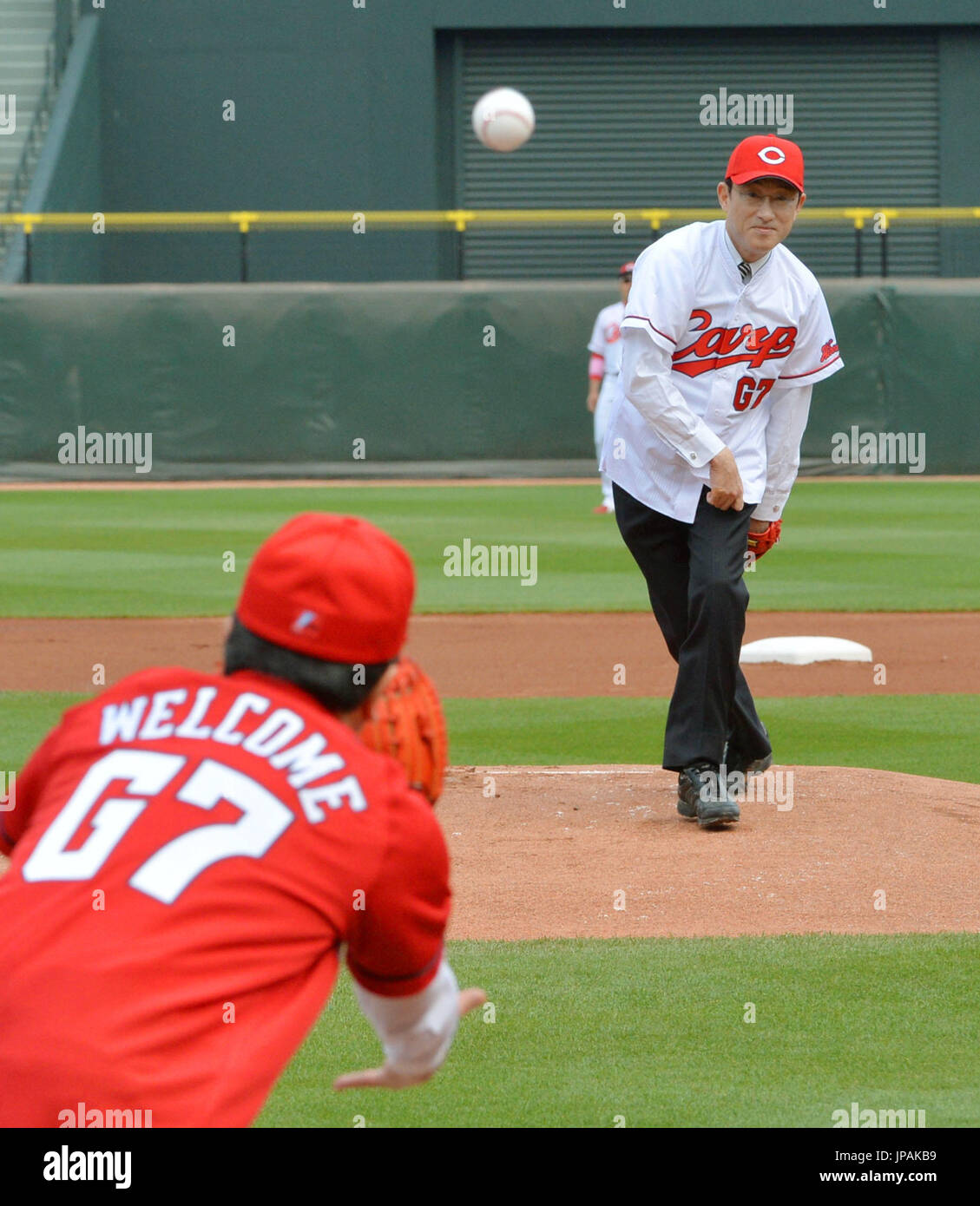 Japanese Foreign Minister Fumio Kishida (back) throws a ceremonial ...
