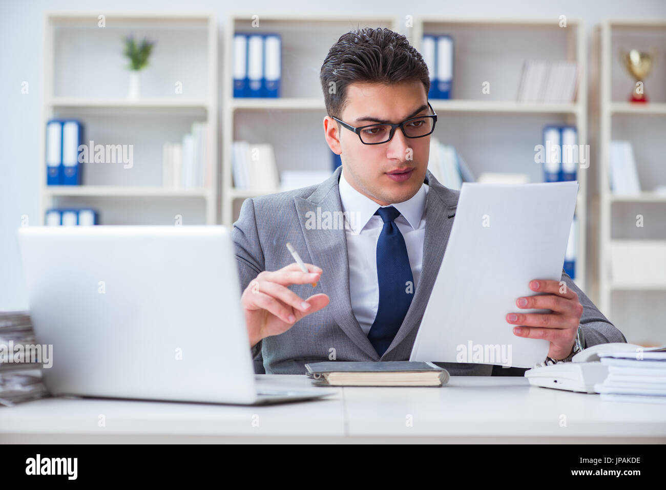 Businessman smoking in office at work Stock Photo - Alamy