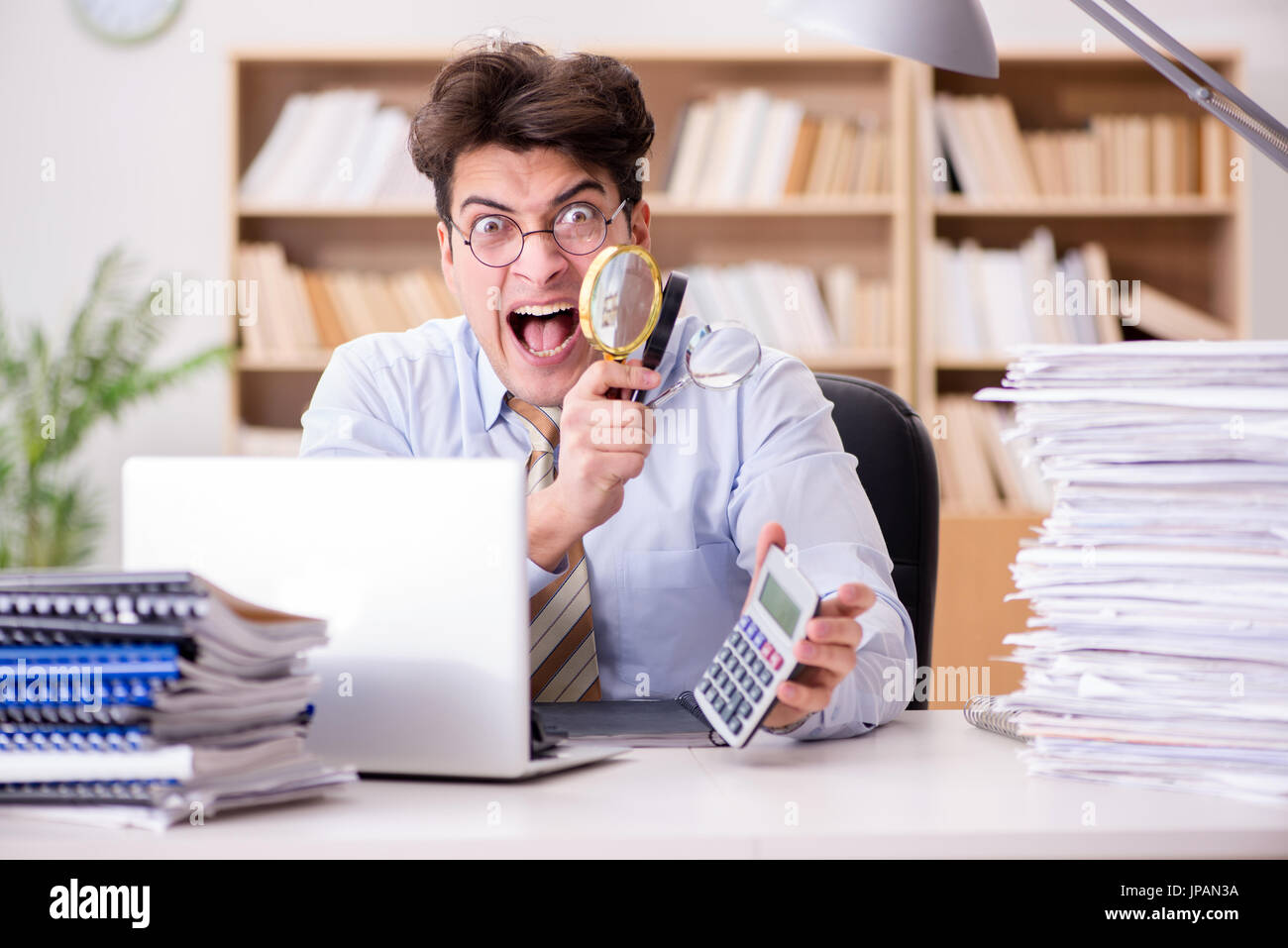 Mad auditor looking for errors in the report Stock Photo - Alamy