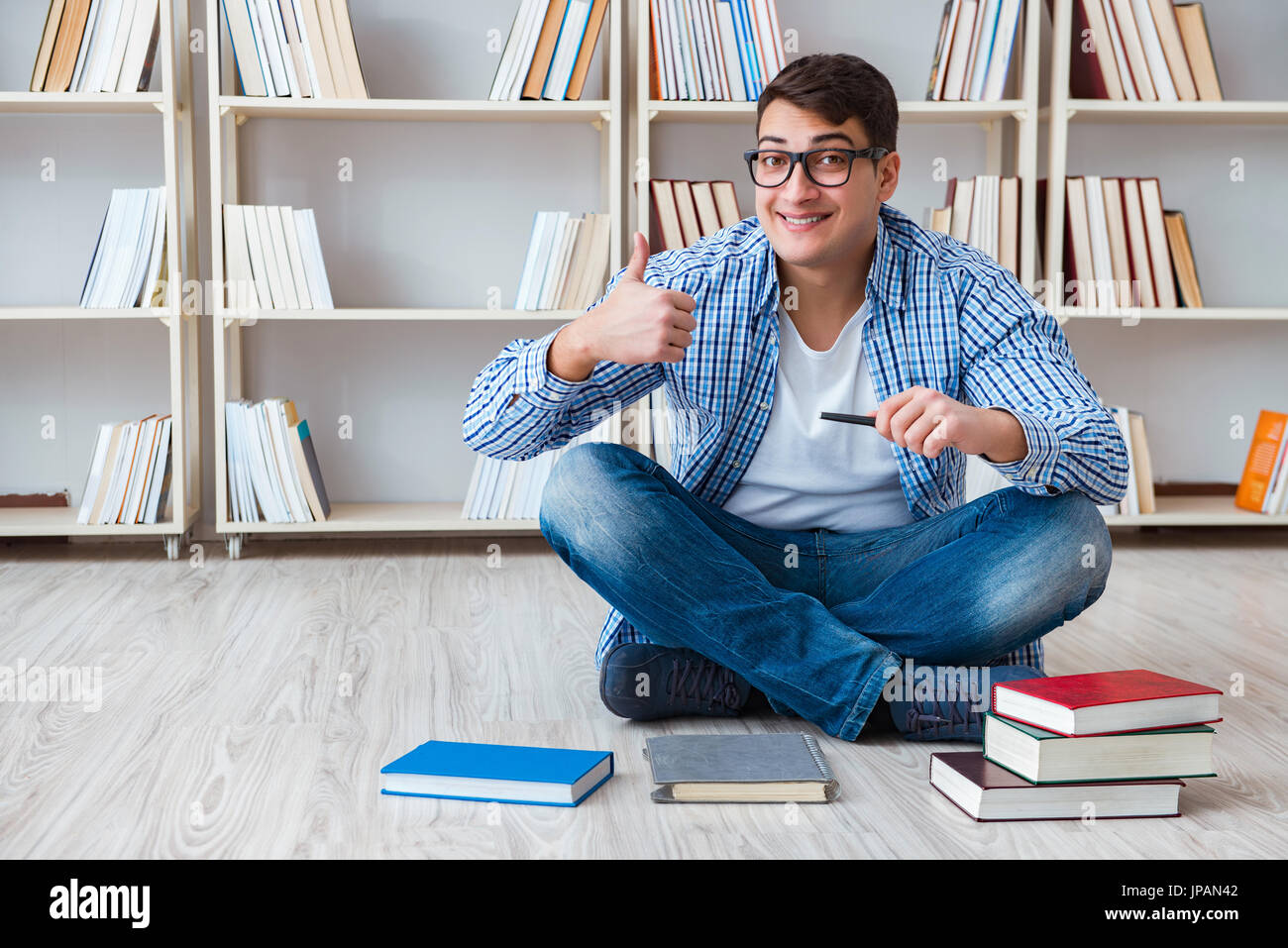 Young student studying with books Stock Photo - Alamy