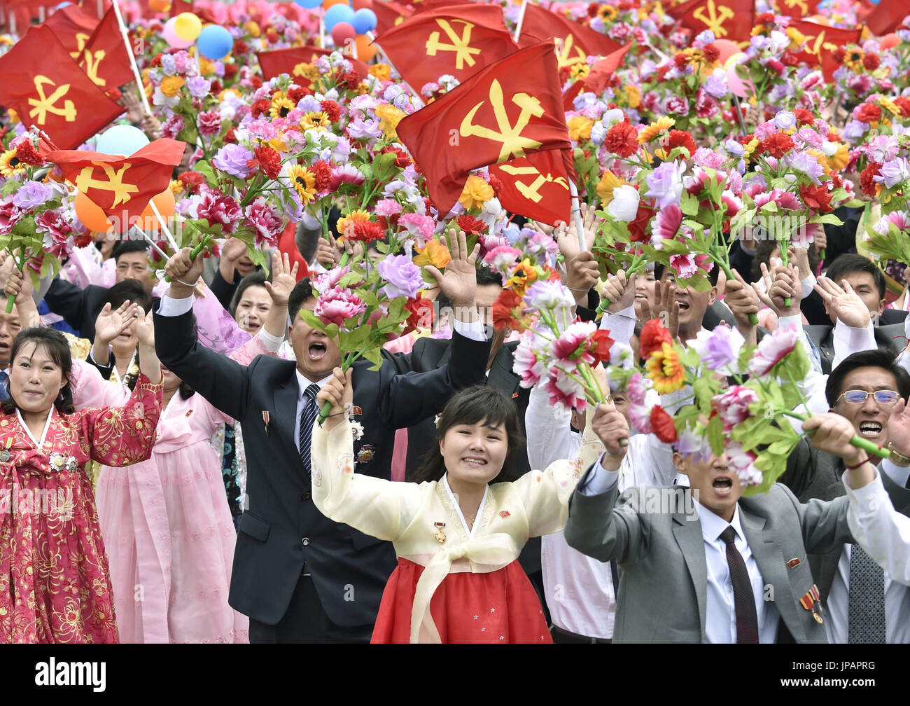 People wave flower bouquets during a parade in Pyongyang's Kim Il Sung ...