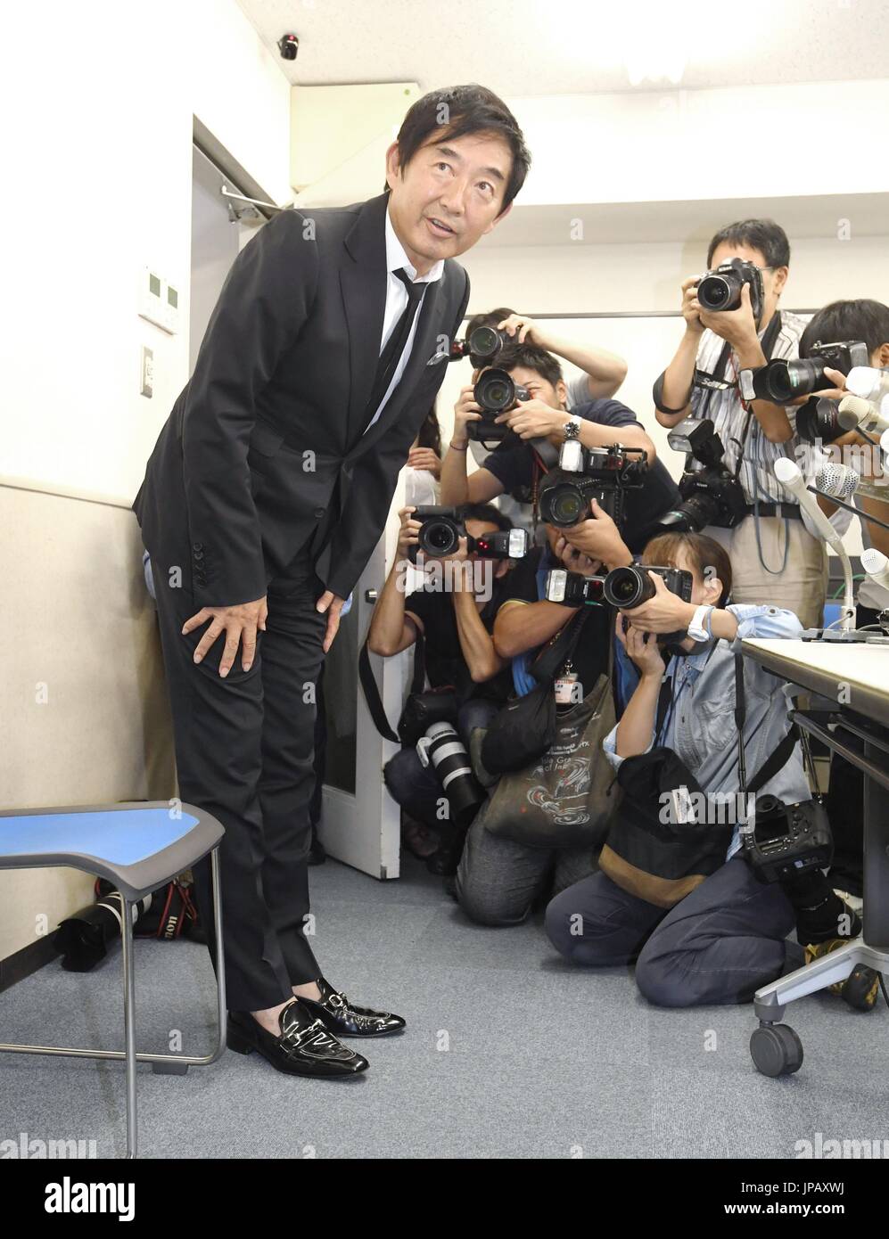 Actor and television personality Junichi Ishida bows after speaking to ...